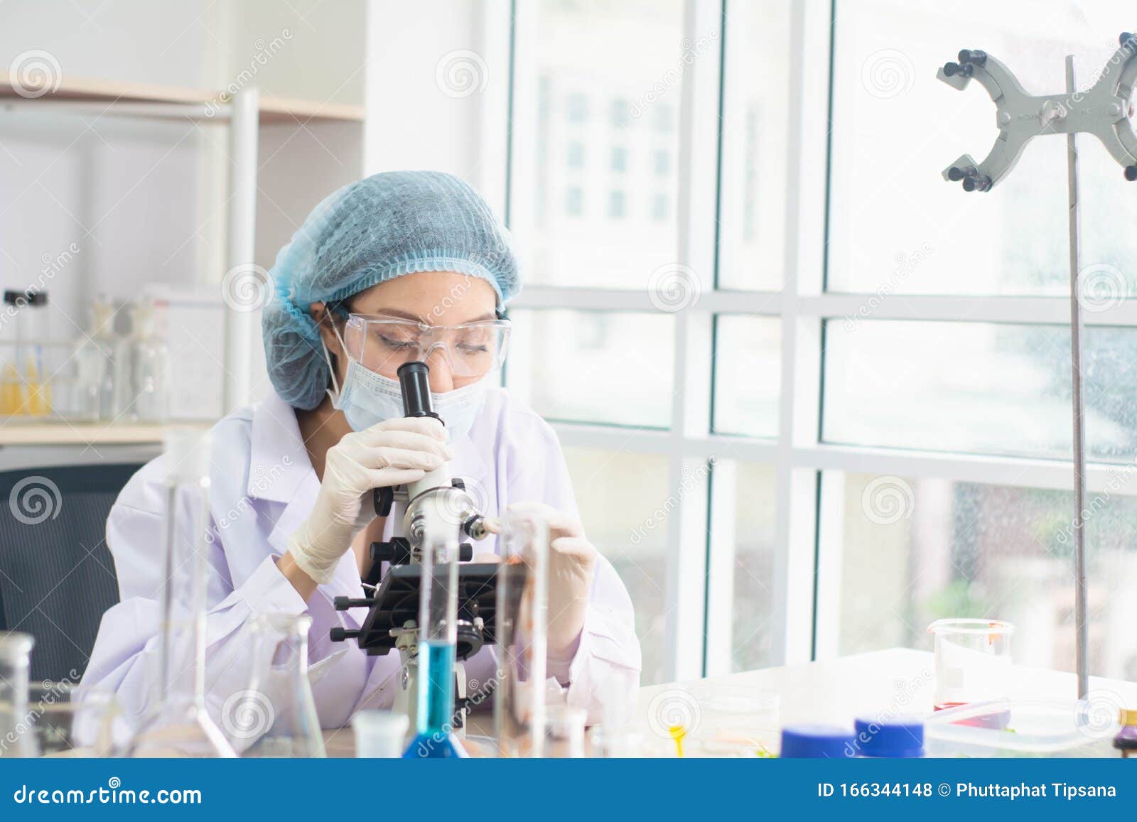 Young Female Scientist in Protective Glasses and Gloves,use Microscope ...