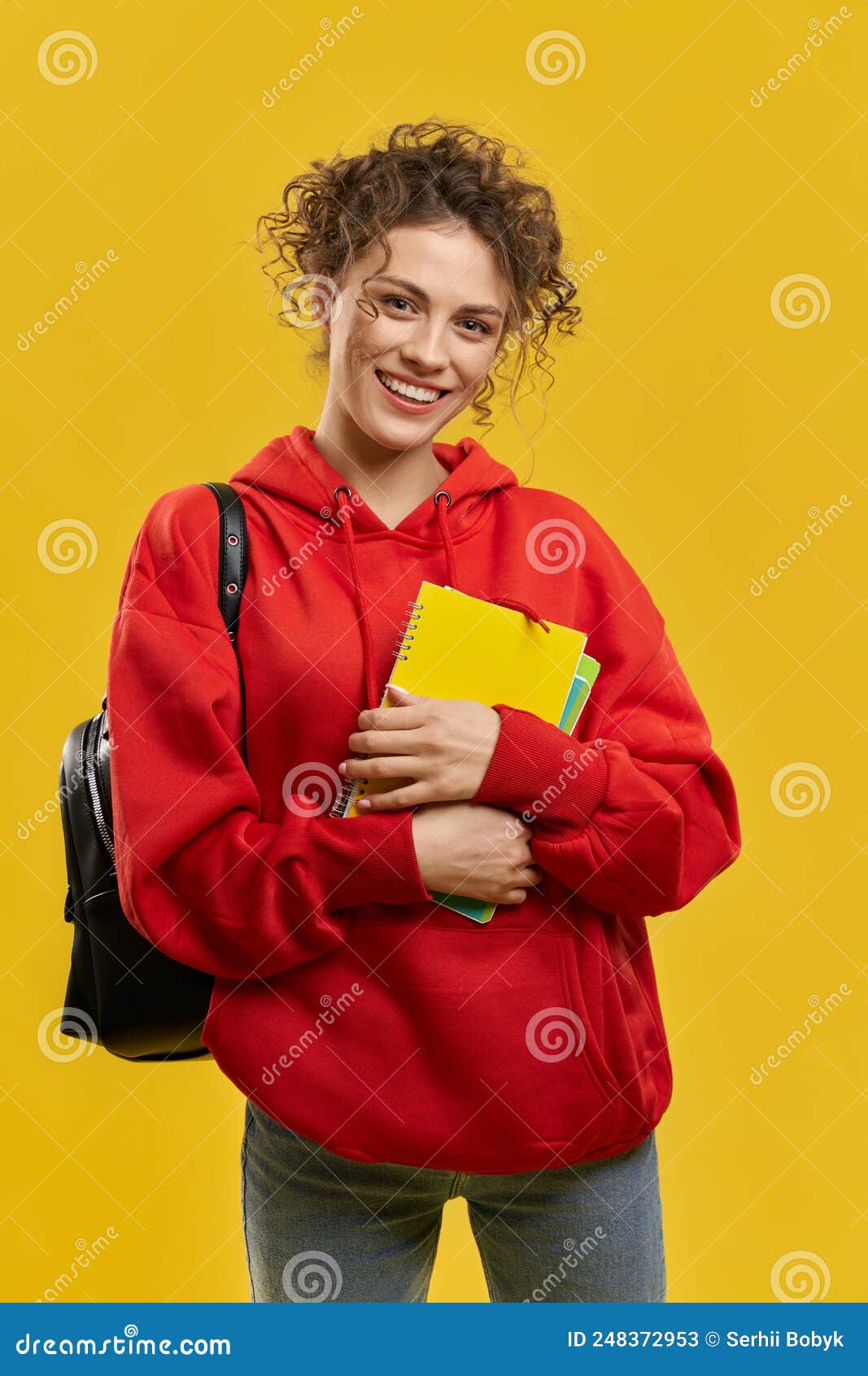 Young Female Student Smiling at Camera while Holding Notes in Studio ...