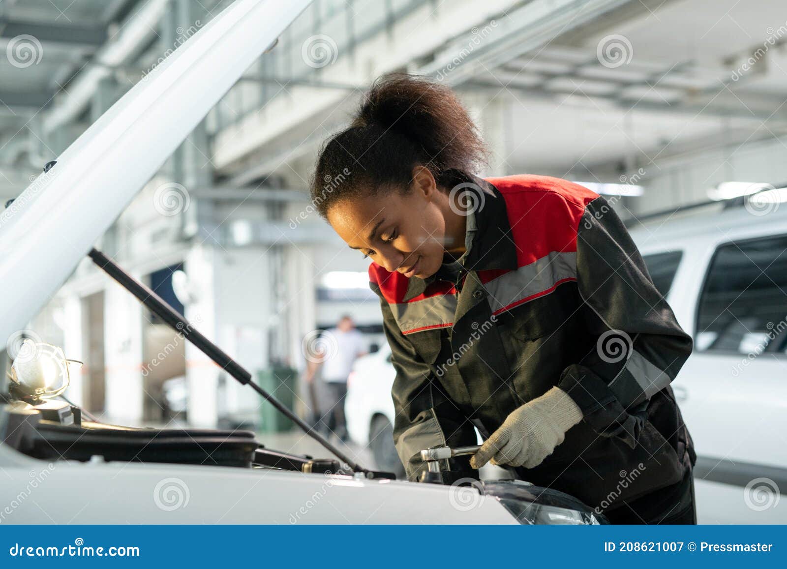 Young Female Worker of Car Repair Service Bending Over Open Engine ...