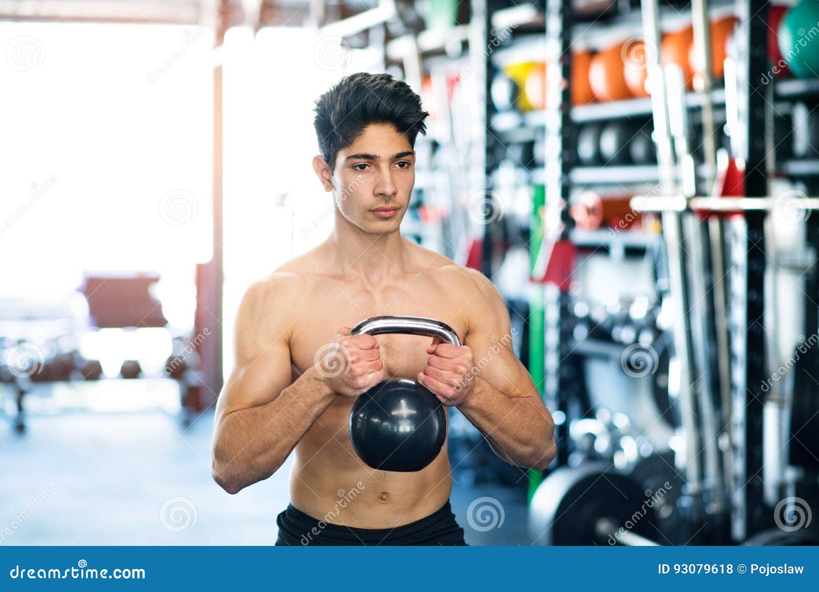 Young Fit Hispanic Man in Gym Exercising with Kettlebell. Stock Photo ...