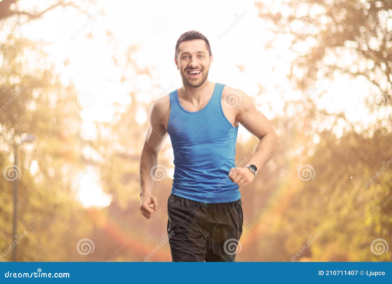 Young Fit Man Running in a Park and Smiling Stock Image - Image of ...