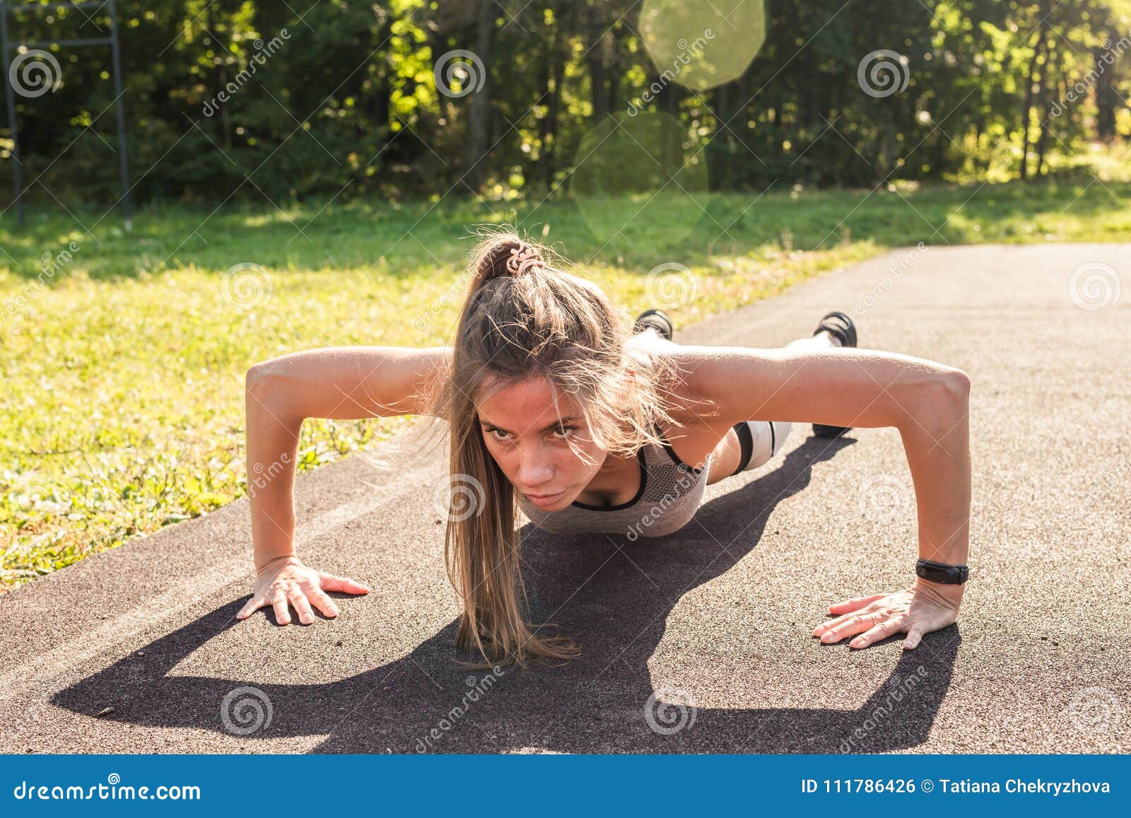 Young Fit Woman Exercising by Doing Push-ups Outdoors Stock Photo ...