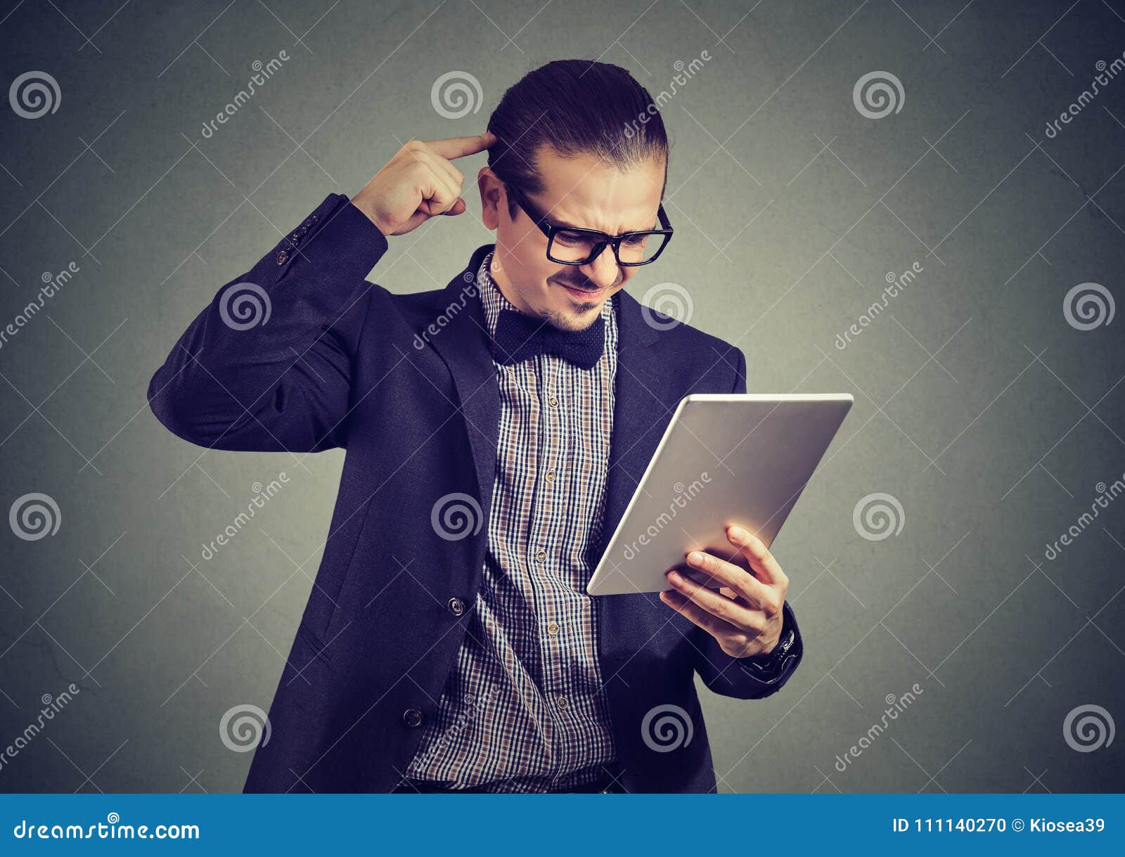Confused Man Watching Tablet on Gray Stock Photo - Image of complicated ...
