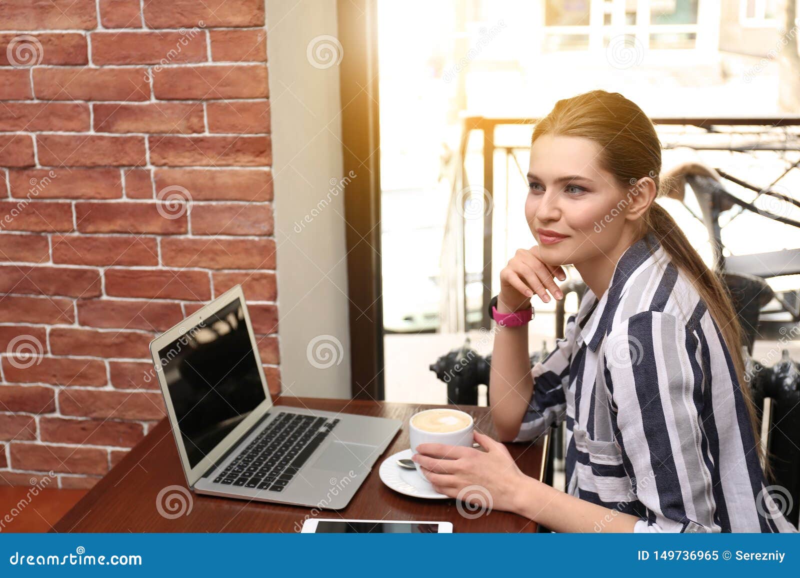 Young Freelancer Drinking Coffee while Working on Laptop in Cafe Stock ...
