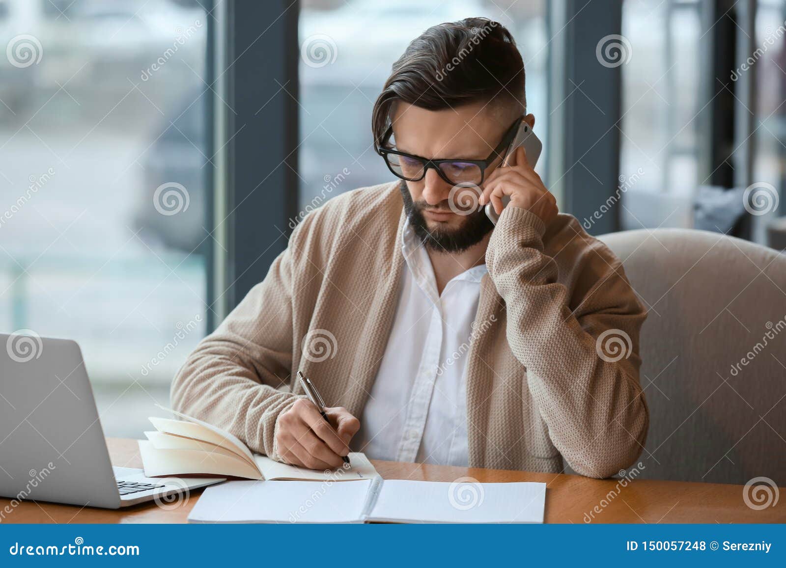 Young Freelancer with Mobile Phone and Laptop Working in Cafe Stock ...