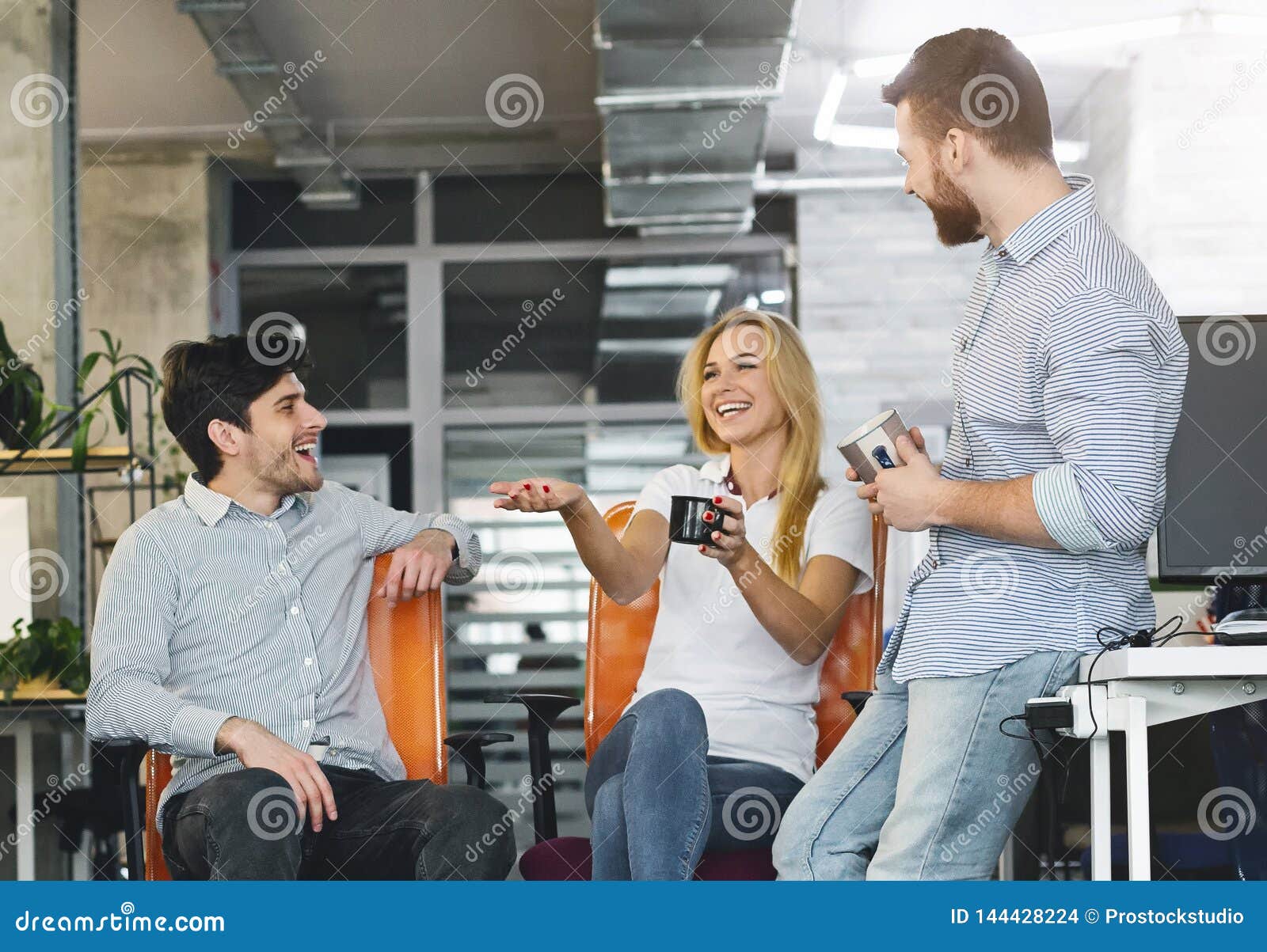 Young Friendly Colleagues Talking and Laughing in Office Stock Photo ...