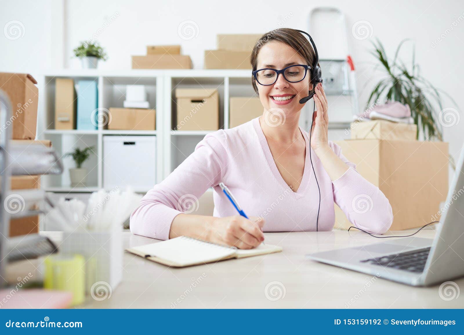 Young Friendly Operator of Call Center or Online Shop Making Notes ...