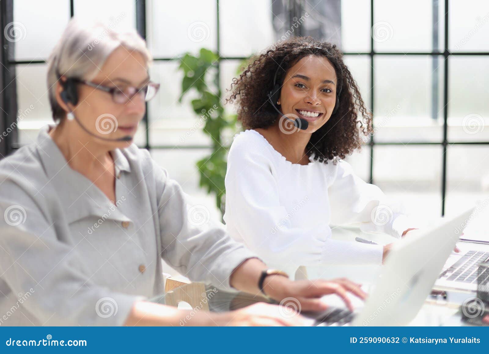 Young Friendly Operator Woman Agent with Headsets Working in a Call ...
