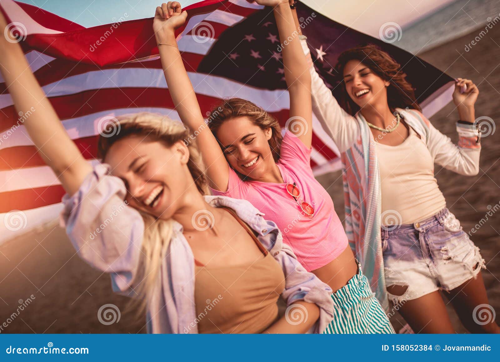 Friends Carrying American Flag on the Beach Stock Photo - Image of ...