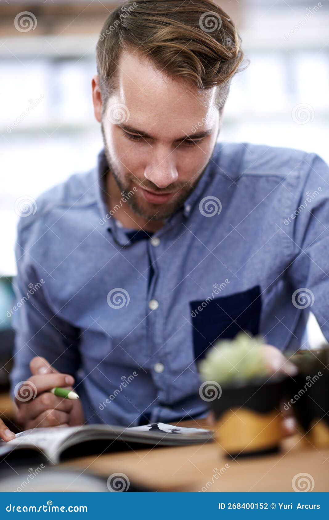 Young and Full of Creativity. a Handsome Young Man Paging through a ...