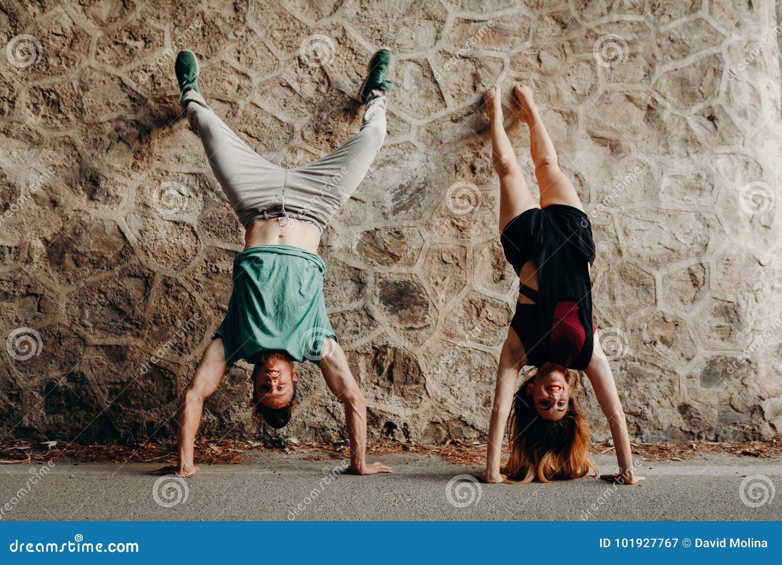 Smiling Young Couple Doing a Handstand Position in a Stone Wall Stock ...