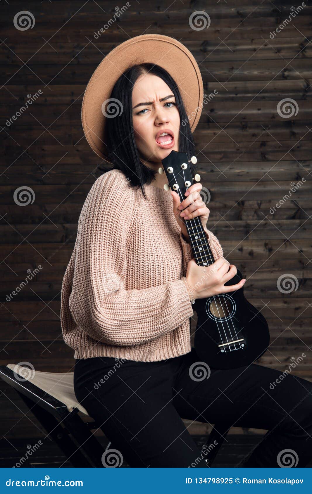 Young Funny Hipster Girl Having Fun And Playing On Small Ukulele Guitar