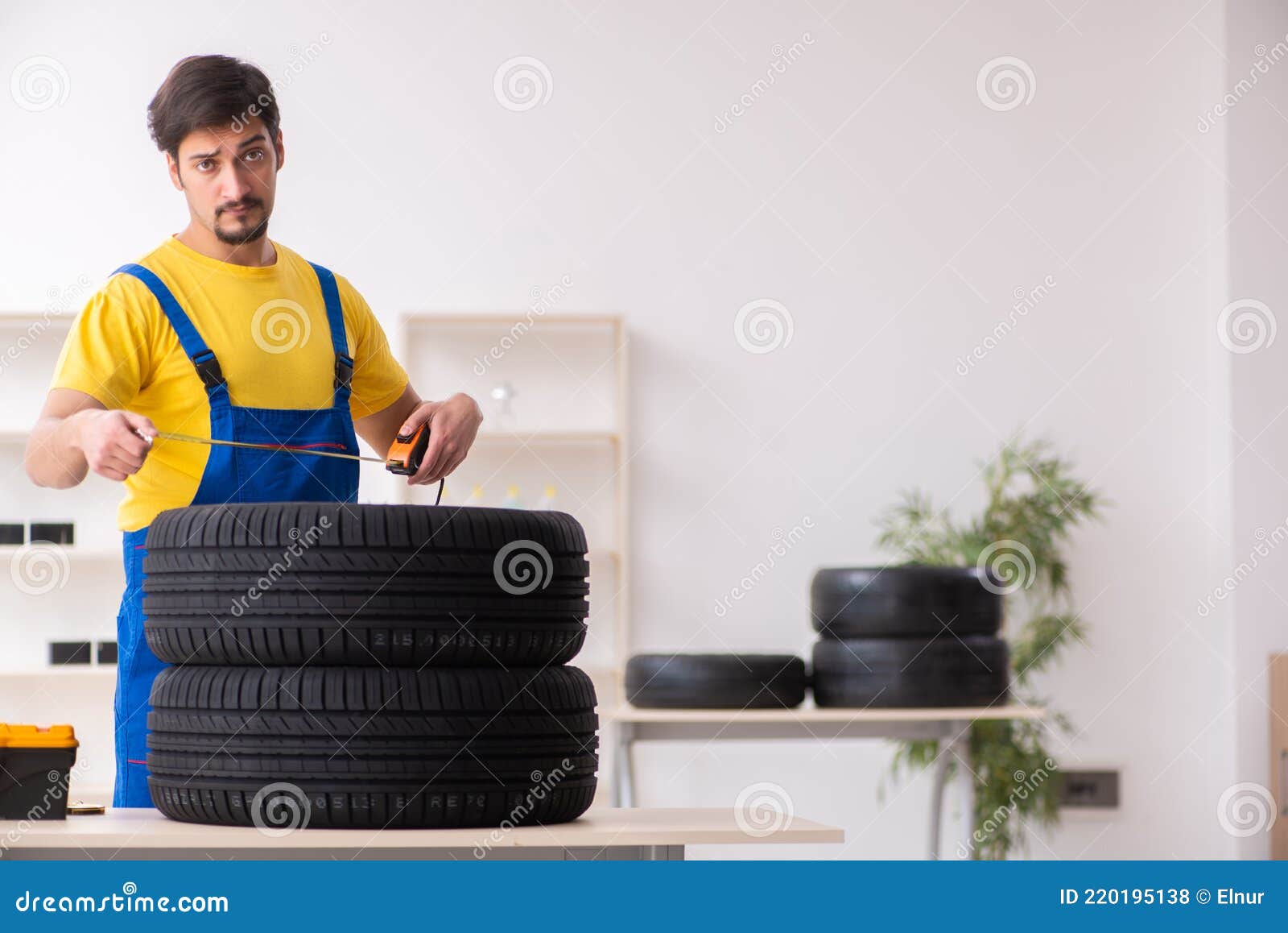 Young Male Garage Worker with Tyre at Workshop Stock Photo - Image of ...