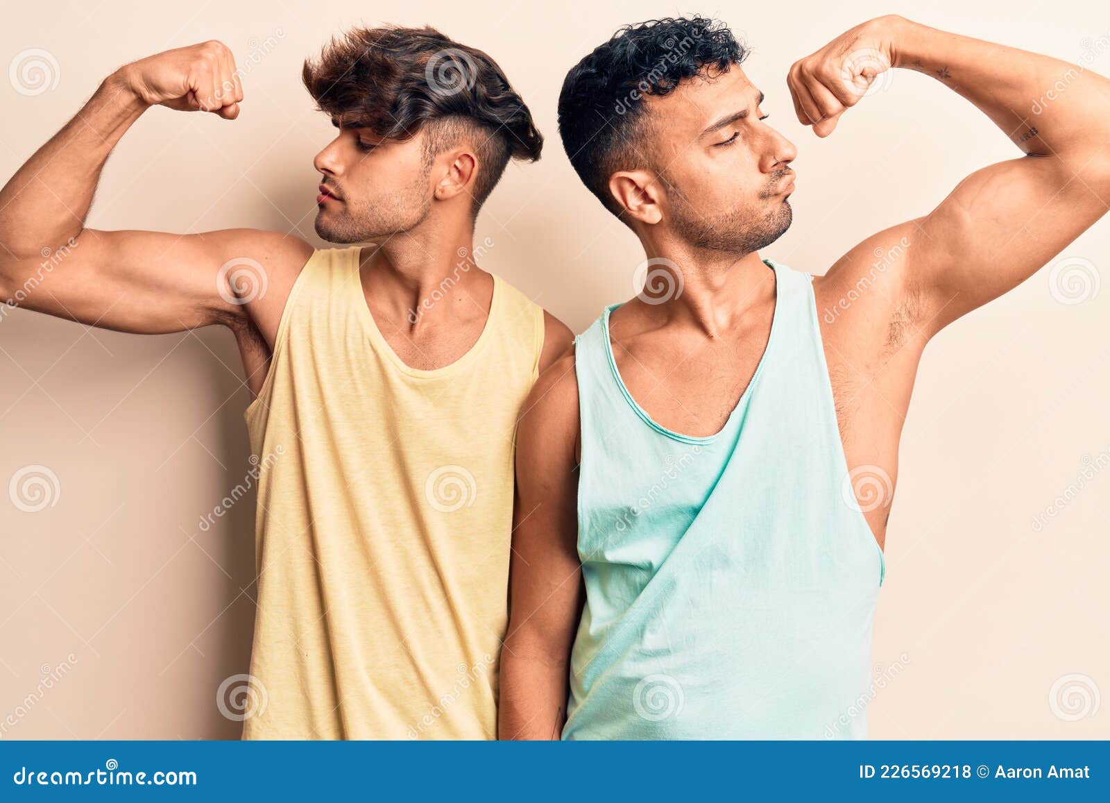 Young Gay Couple Wearing Casual Clothes Showing Arms Muscles Smiling