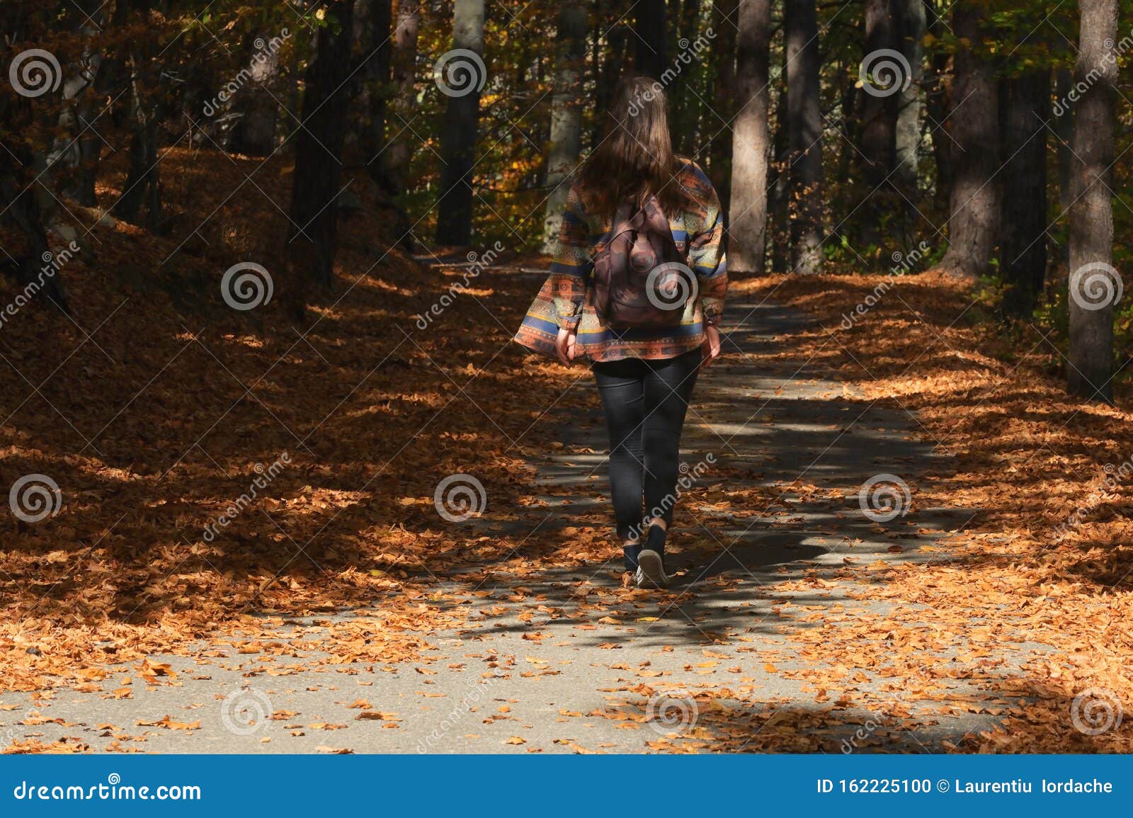 A Young Girl with a Backpack is Walking through a Forest Stock Photo ...