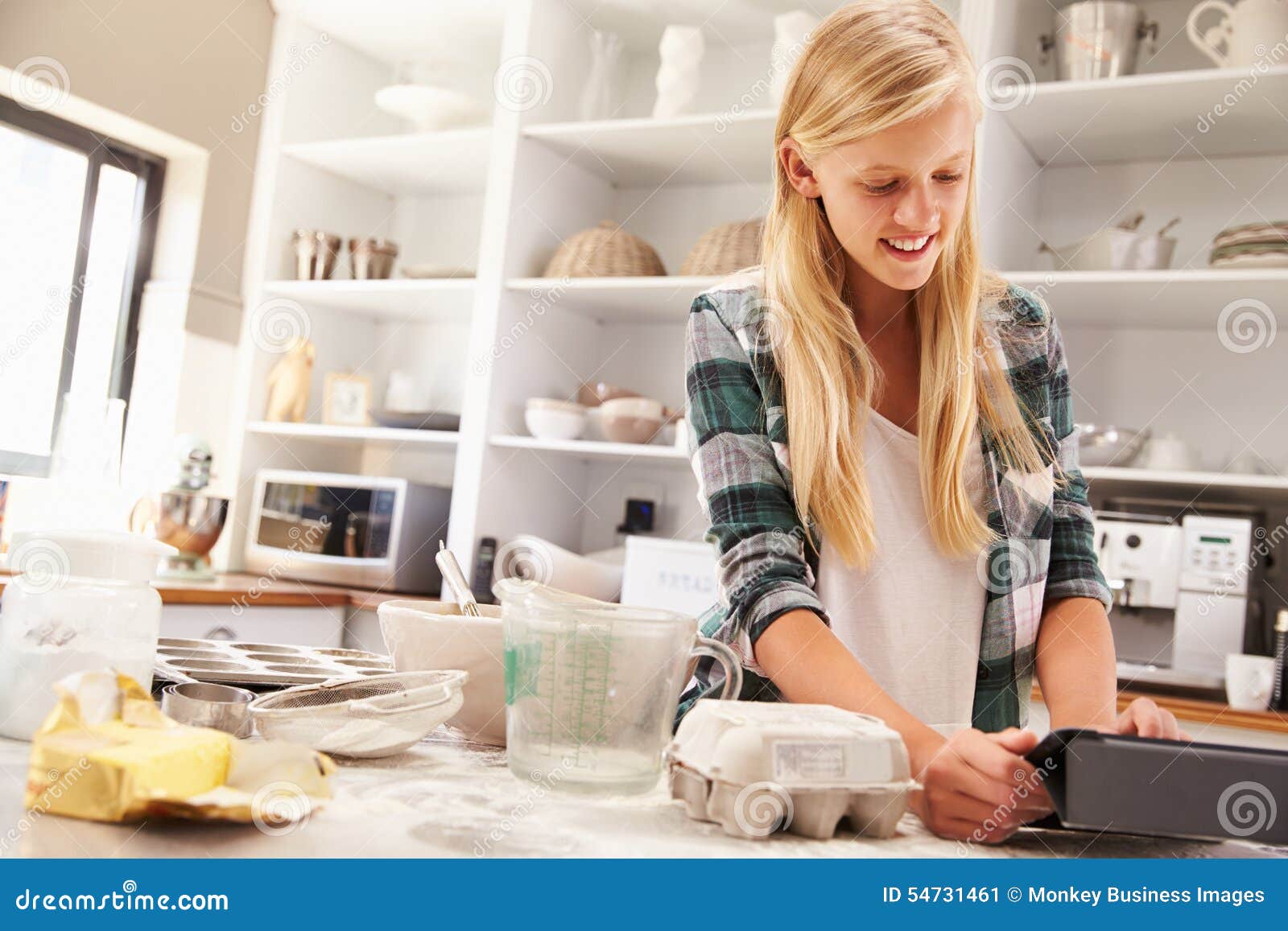 Young Girl Baking Following Recipe on a Tablet Stock Image - Image of ...