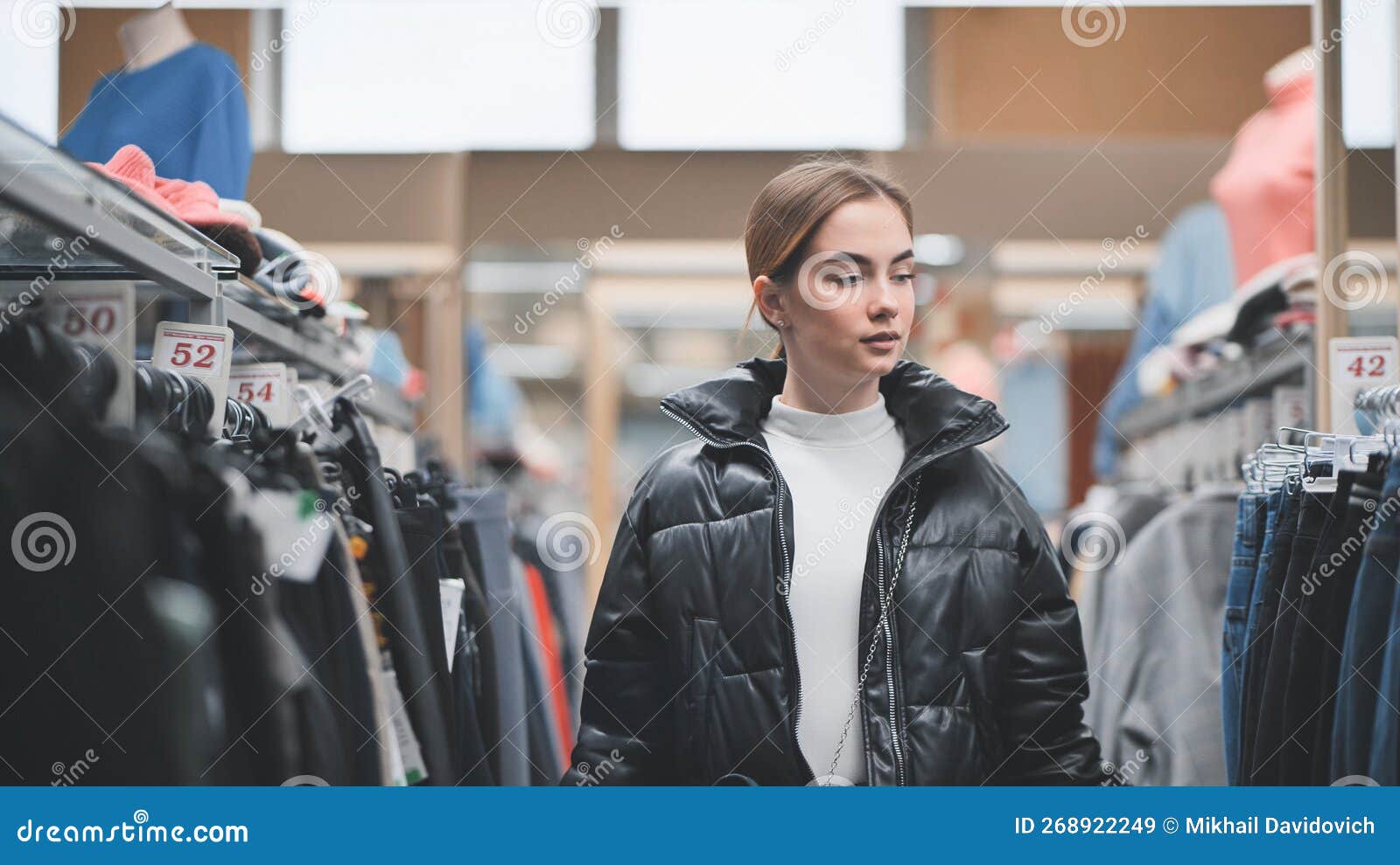 A Young Girl Choosing and Looking at Clothes in the Store. Stock Image ...