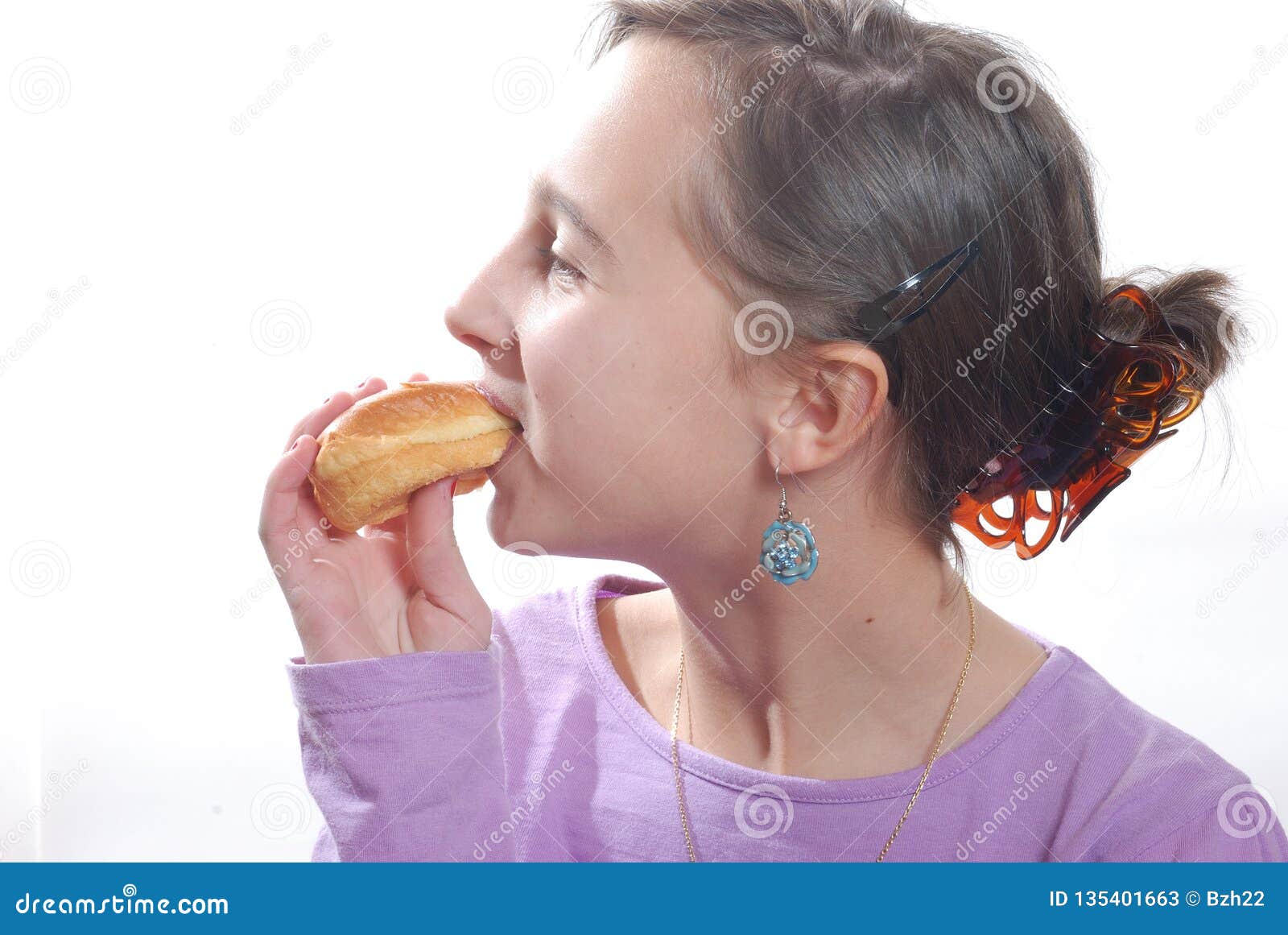Young girl eating a bun stock image. Image of hungry - 135401663