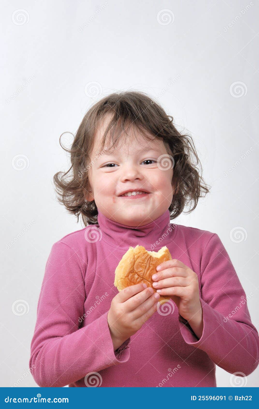 Young girl eating a bun stock image. Image of childhood - 25596091