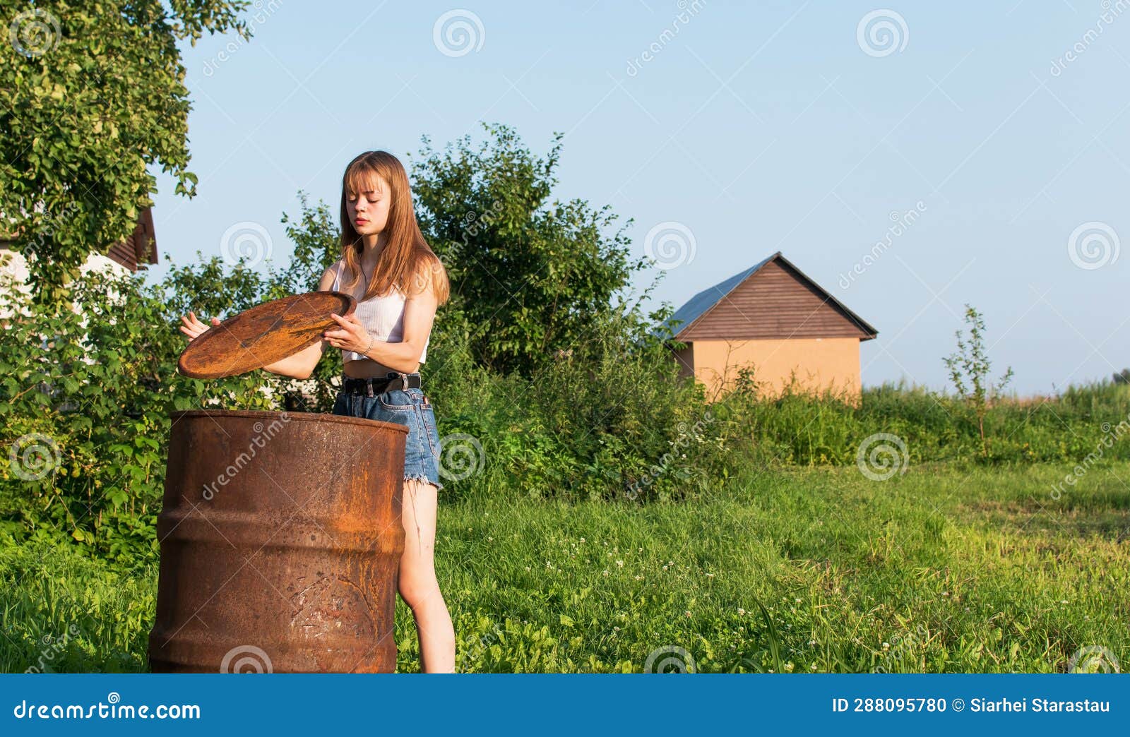 A Young Girl Examines an Iron Barrel Stock Photo - Image of color ...