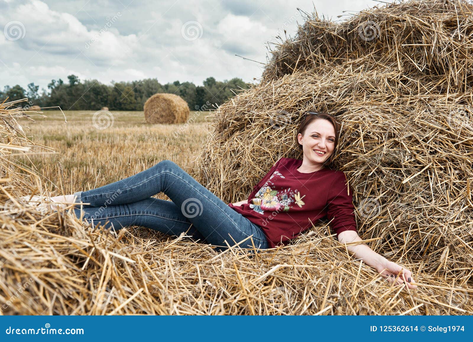 Young Girl Having Fun In The Field, Lying On A Haystack Stock Photo ...