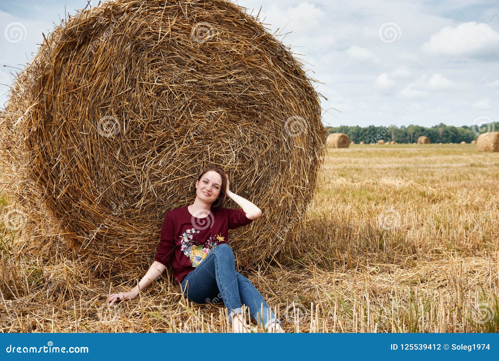 Young Girl Having Fun in the Field, Sits in a Haystack and Relaxing ...