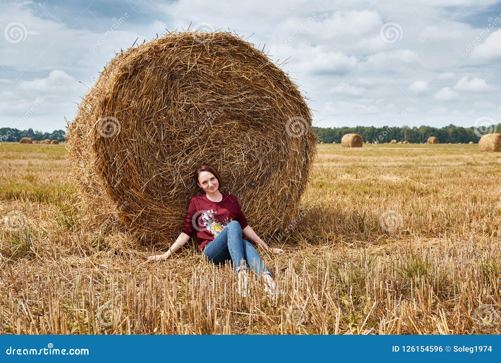 Young Girl Having Fun in the Field, Sits in a Haystack and Relaxing ...