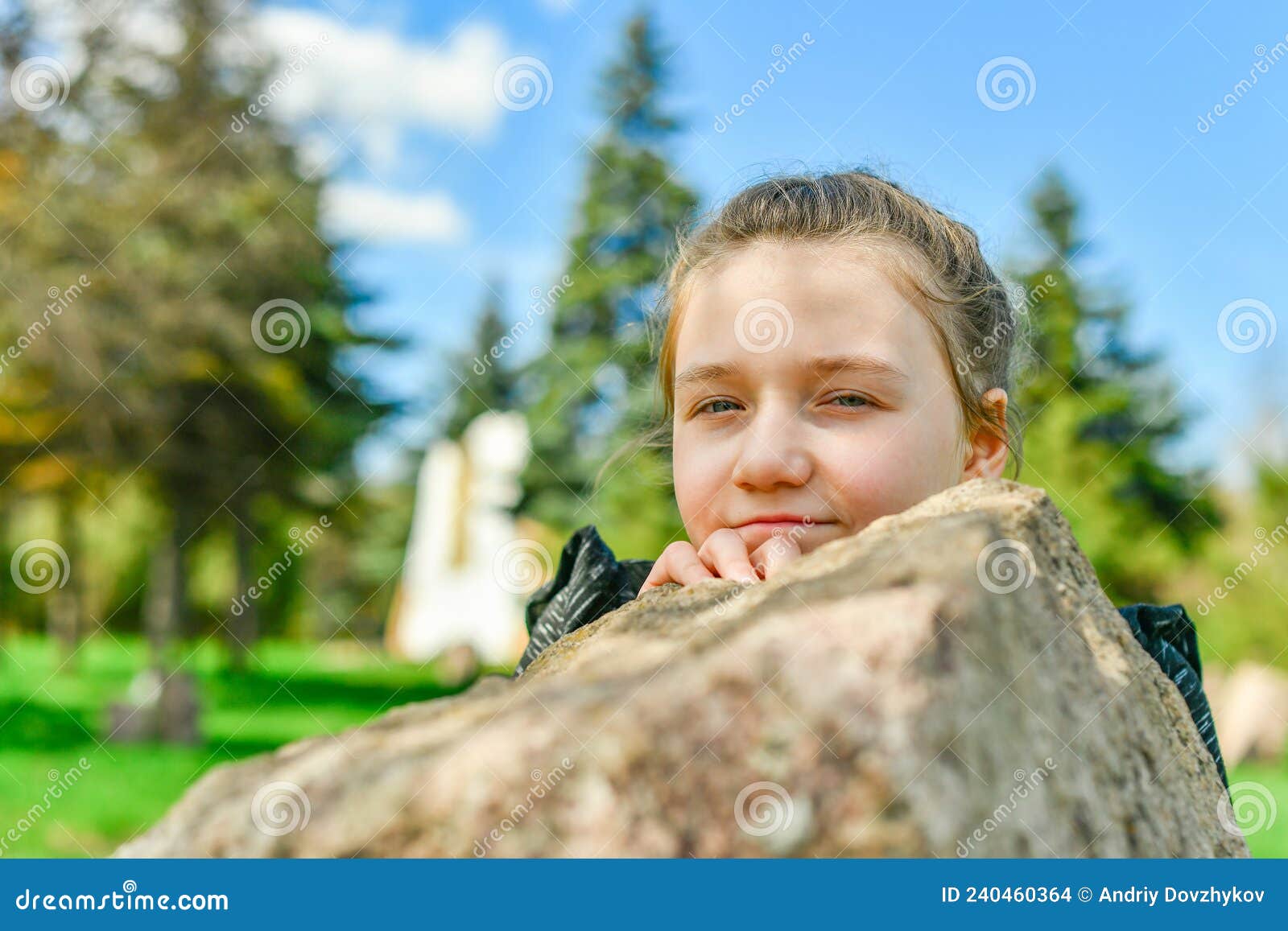A Young Girl Hid Behind a Stone and Looks into the Camera Stock Photo ...