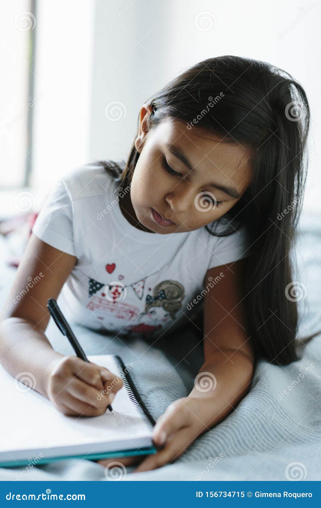 Young Girl Lying On Bed Writing On A Notebook Stock Image Image Of