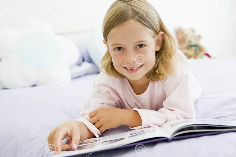 Young Girl Lying On Her Bed In Her Reading A Book Stock Image Image