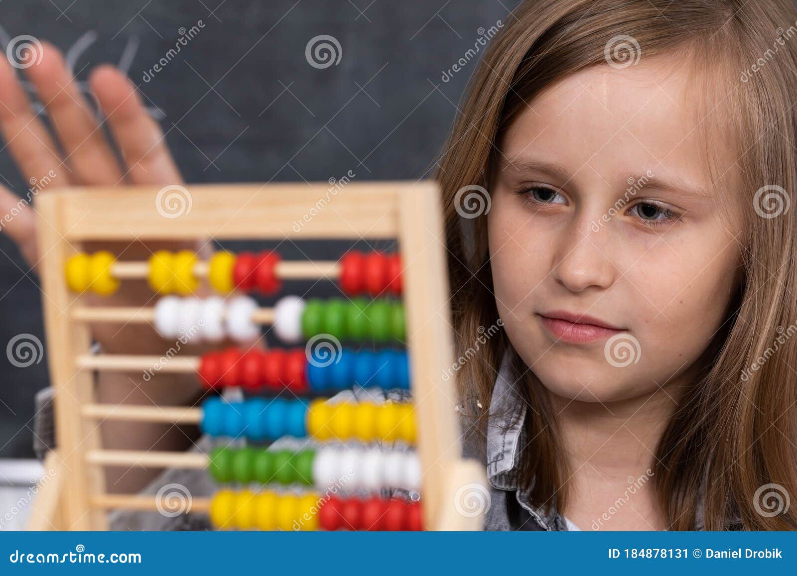A Young Girl at a Maths Lesson Calculates the Result of a Problem on ...
