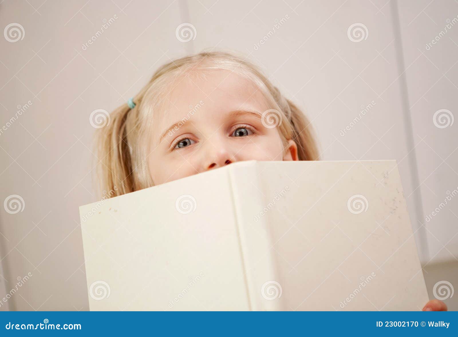 A Young Girl Peers Over a Book Stock Photo - Image of excited ...
