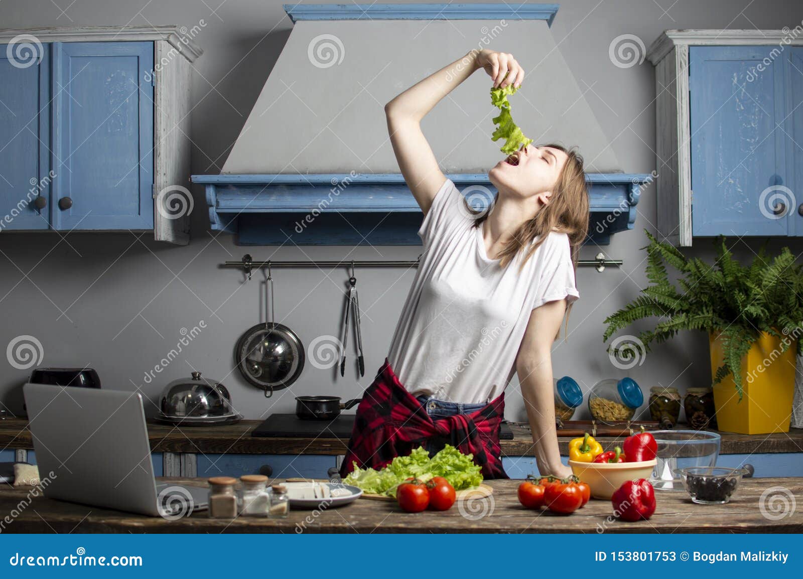 Young Girl Prepares A Vegetarian Salad In The Kitchen She Looks Into A