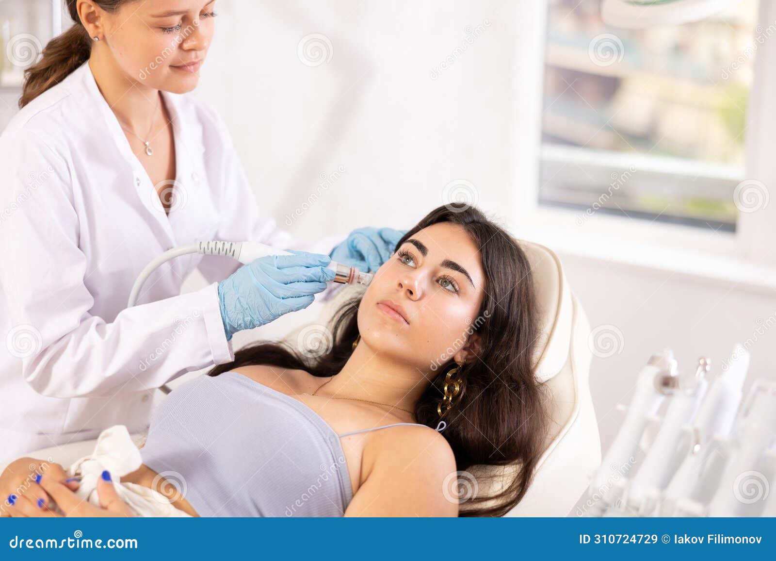 Young Girl Receiving Facial Procedure with Hydrogen and Oxygen Ions ... Young Girl Receiving Facial Procedure with Hydrogen and Oxygen Ions ...