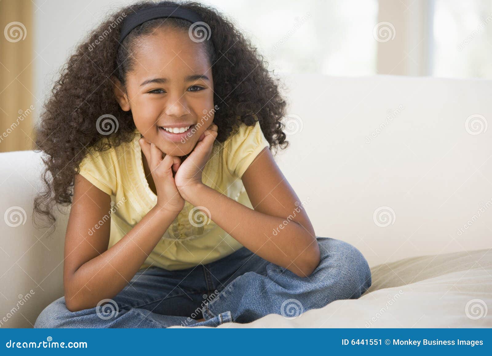 Young Girl Sitting Cross Legged on a Sofa at Home Stock Image - Image ...