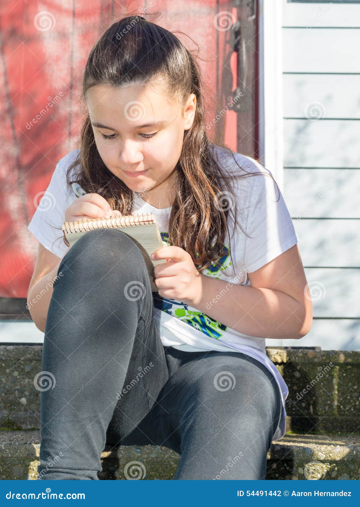Young Girl Sitting Down Writing in Notepad Stock Photo - Image of ...