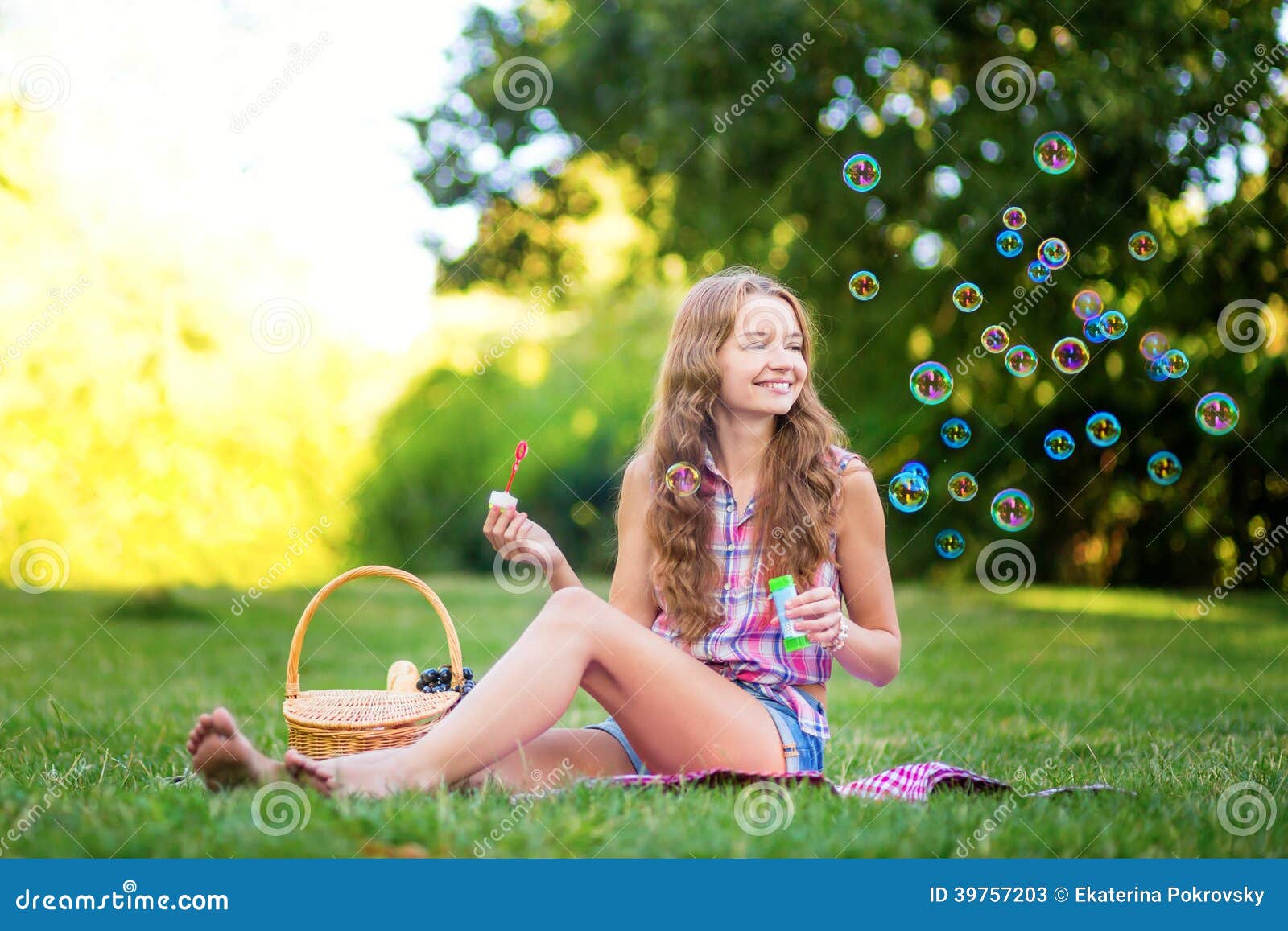 Young Girl Sitting on the Grass Blowing Bubbles Stock Image - Image of ...