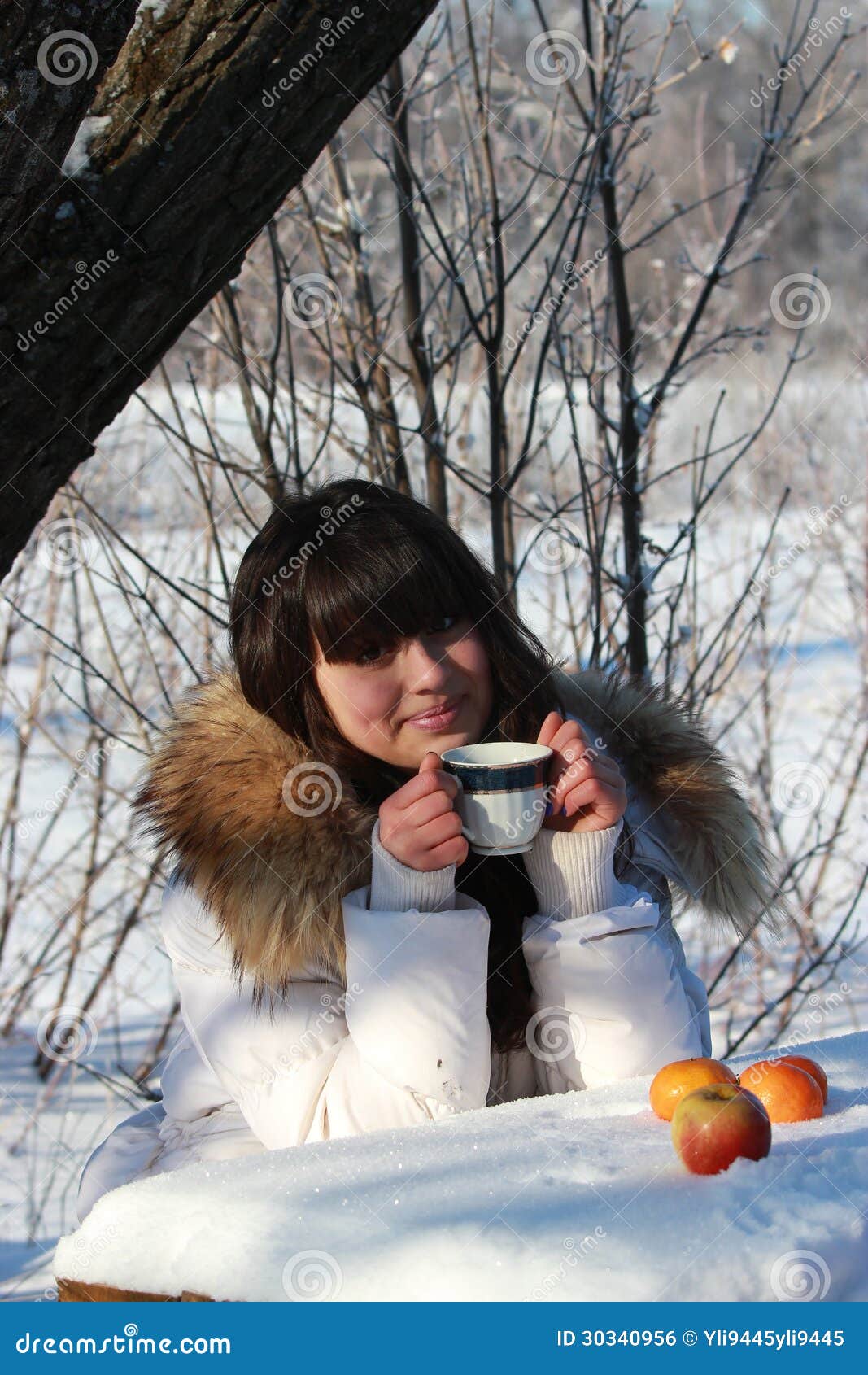 A Young Girl Sitting at a Table in a Winter Forest, Drinking Tea Stock ...