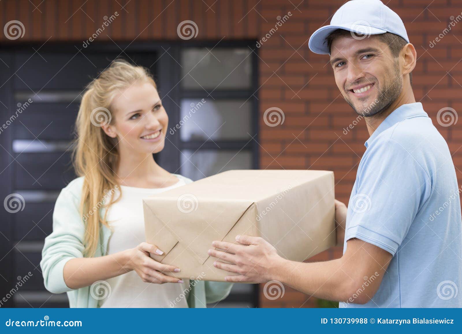 Girl Taking a Delivery Form Handsome Courier in Blue Uniform Stock ...