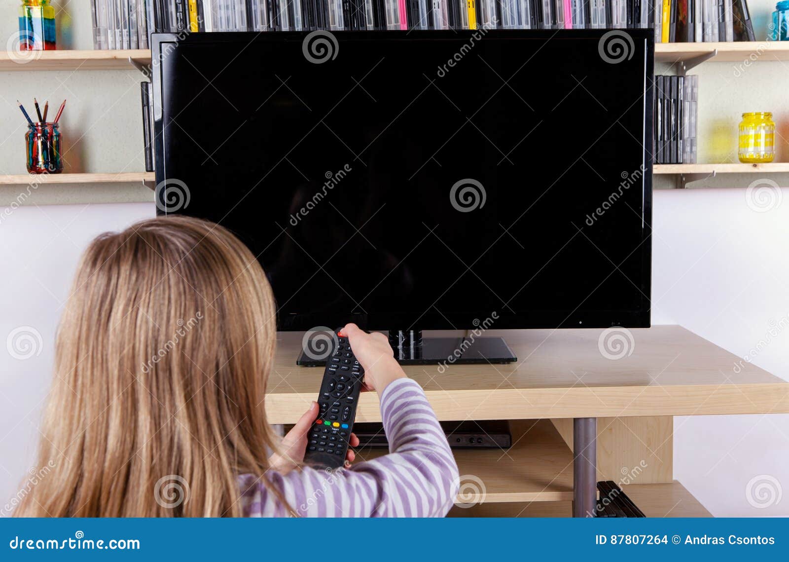 Young Girl Turning on or Off the TV with a Remote Control Stock Photo ...