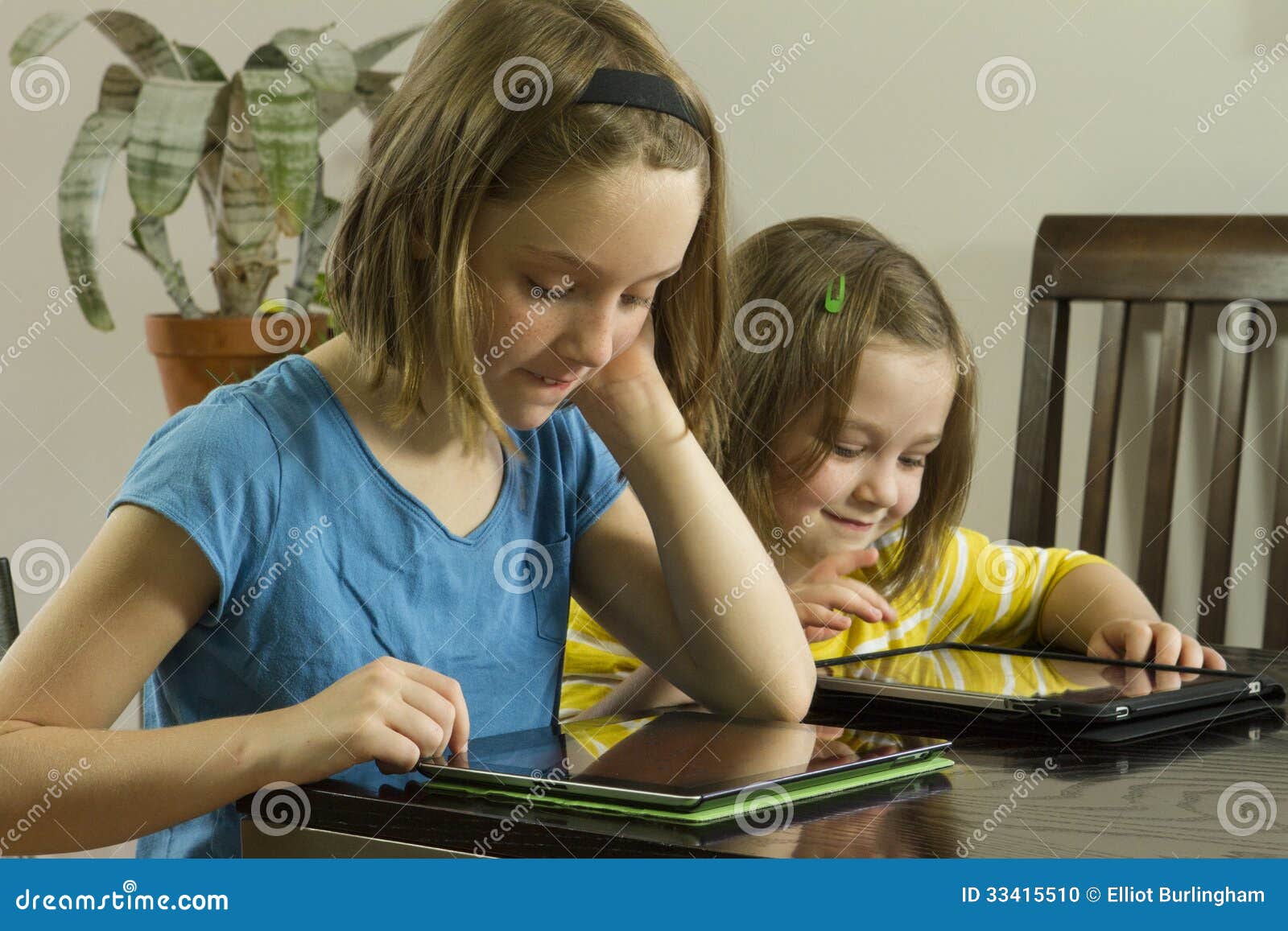 Young Girls at Table Doing Homework on Tablets, Horizontal Stock Photo ...