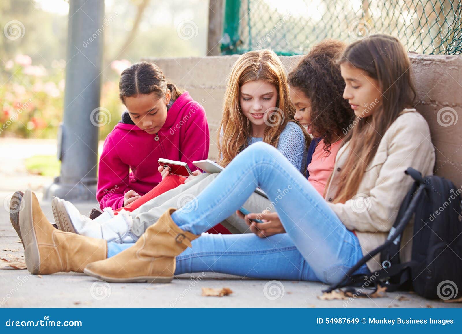 Young Girls Using Digital Tablets and Mobile Phones in Park Stock Image ...