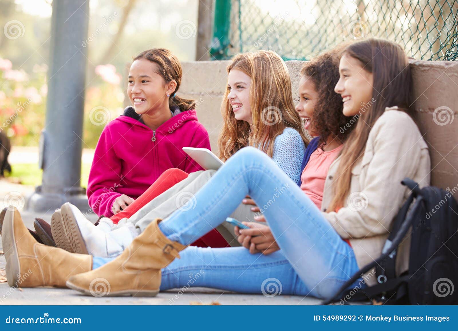 Young Girls Using Digital Tablets and Mobile Phones in Park Stock Photo ...