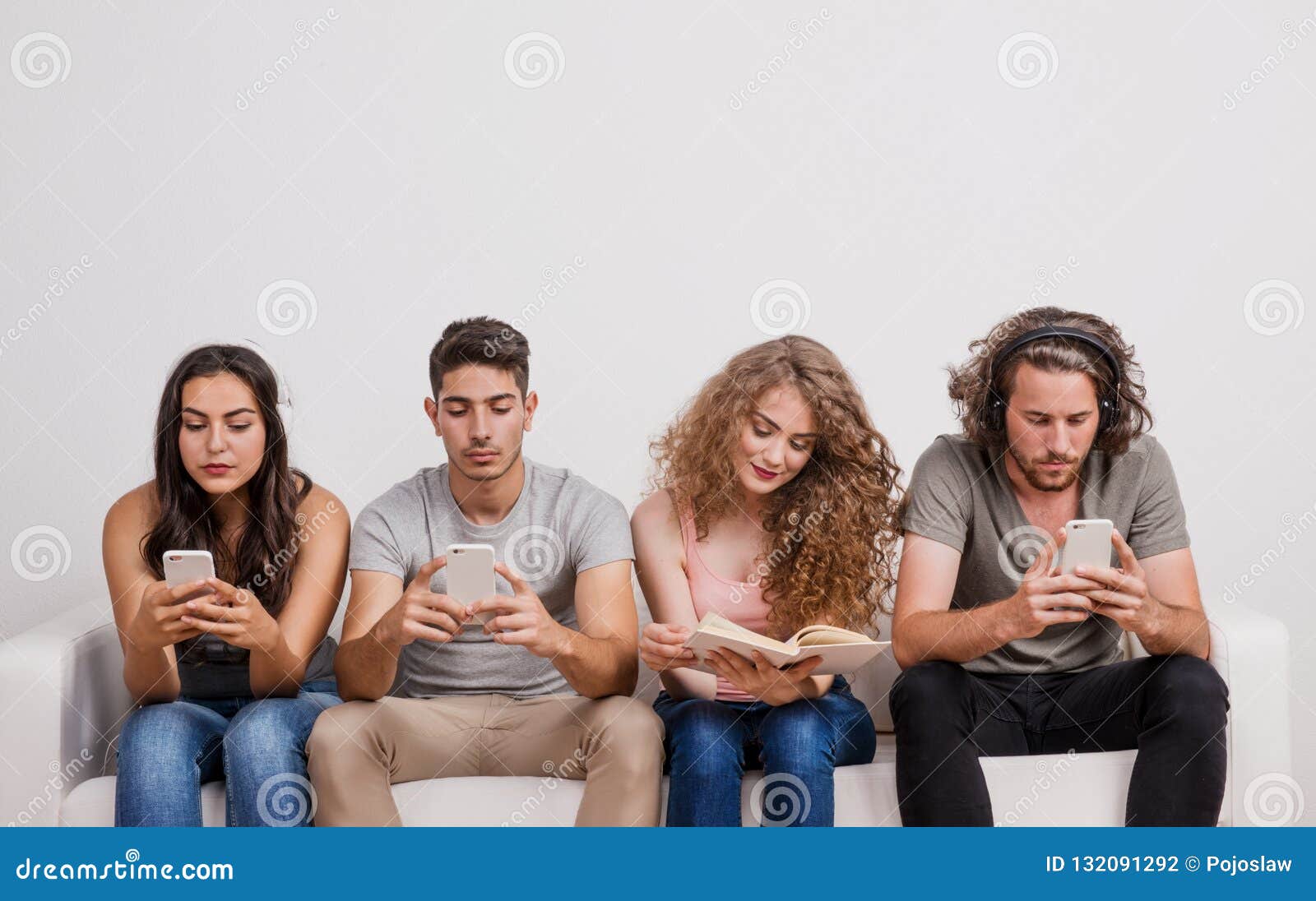 Young Group of Friends Using Modern Technology and Traditional Source ...