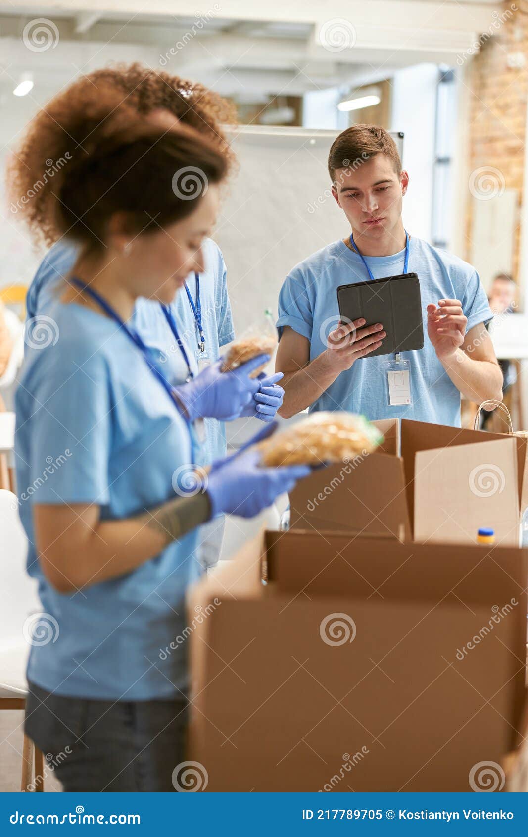 Young Guy Calculating Using Tablet Pc. Volunteers in Protective Gloves ... Young Guy Calculating Using Tablet Pc. Volunteers in Protective Gloves ...