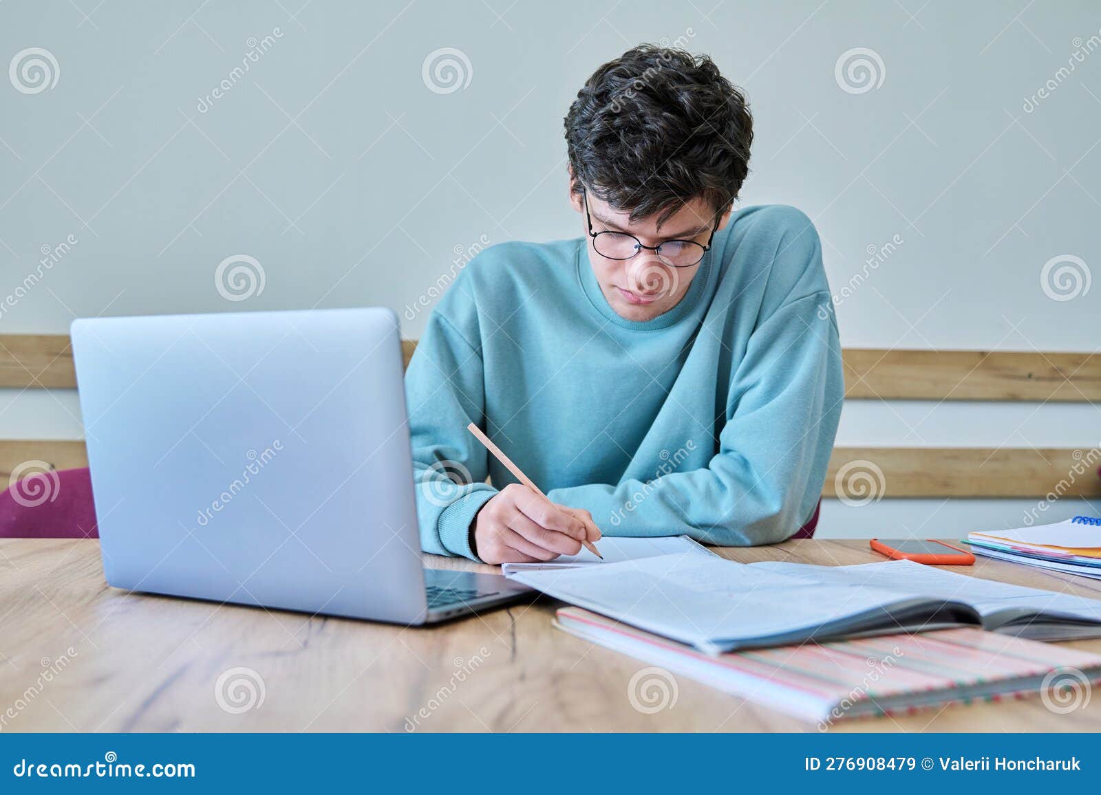 Young Guy College Student Sitting at Desk in Classroom, Using Laptop ...