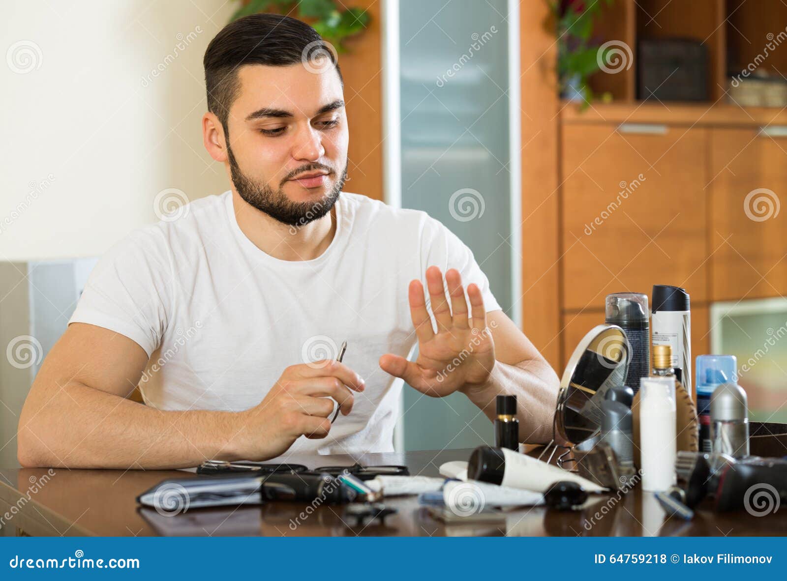 Young guy cutting nails stock photo. Image of american - 64759218