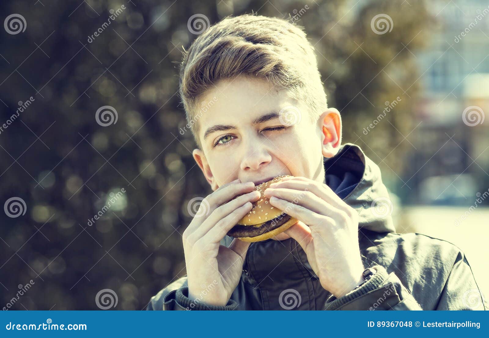 Young Guy Eating a Cheeseburger Stock Photo - Image of cheeseburger ...