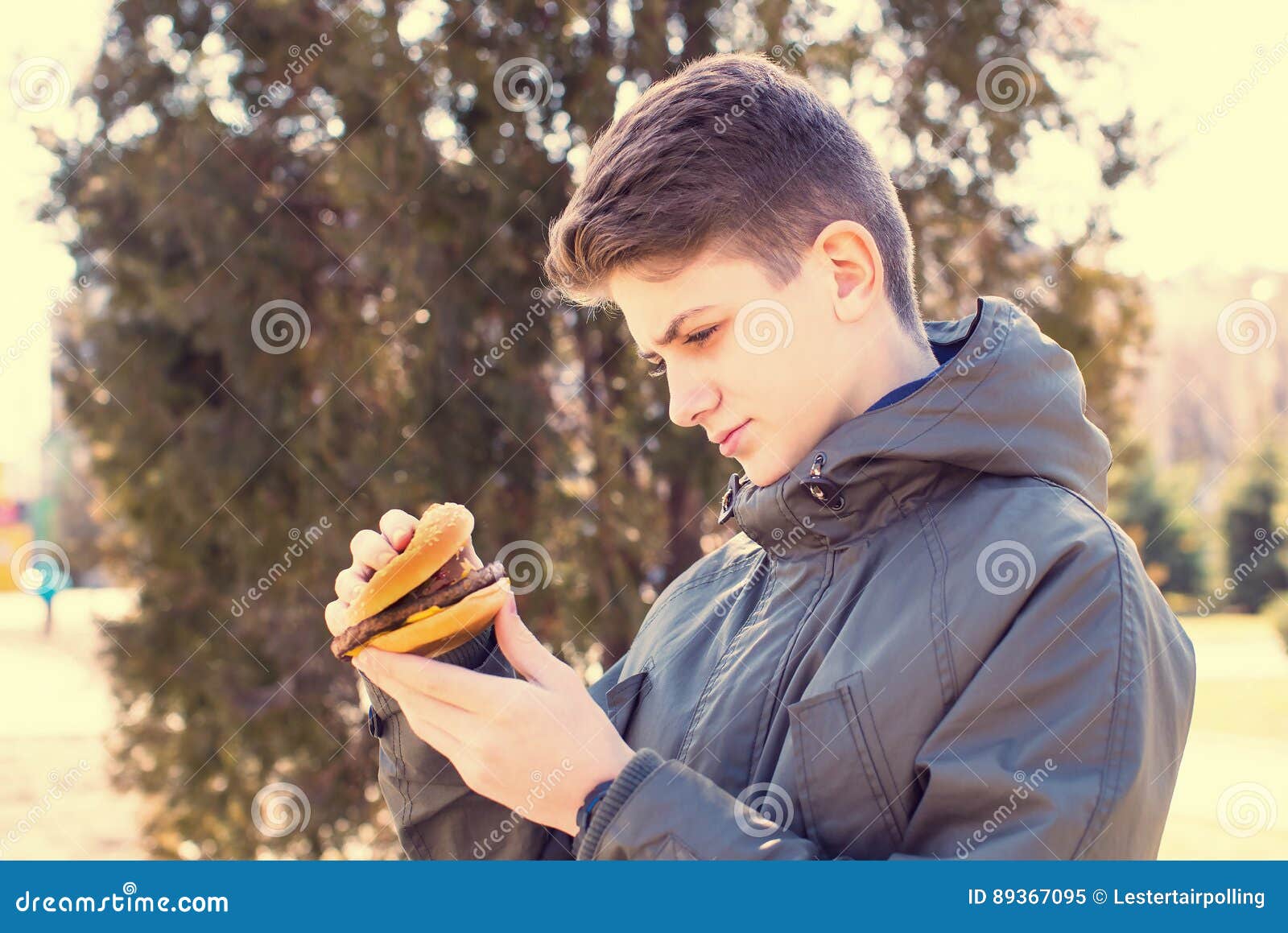 Young Guy Eating a Cheeseburger Stock Image - Image of beef ...