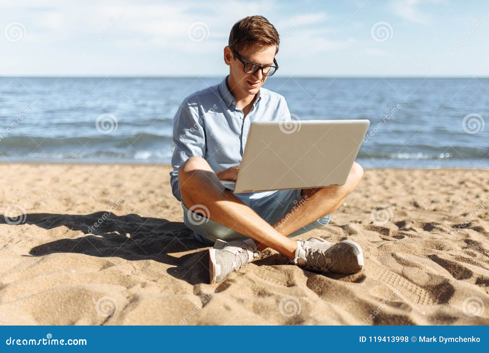 Young Guy with Glasses, Working on His Laptop on the Beach, Work on ...